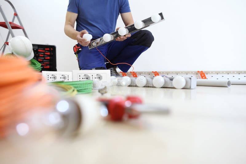 Electrician at Work Installing Lamp, with Bulb, Install Electric ...