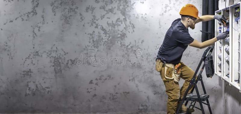 Electrician Working in Switchboard with Electrical Connection Cable ...