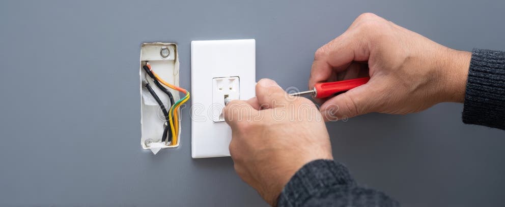 The Electrician Working on a Wall Socket Installation with Tools and ...
