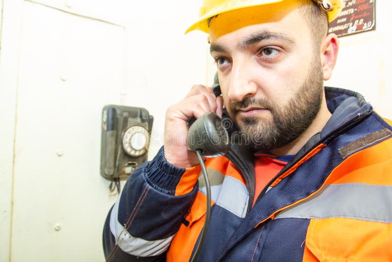 Electrician with Yellow Helmet at Work in a Power Station Talking on ...