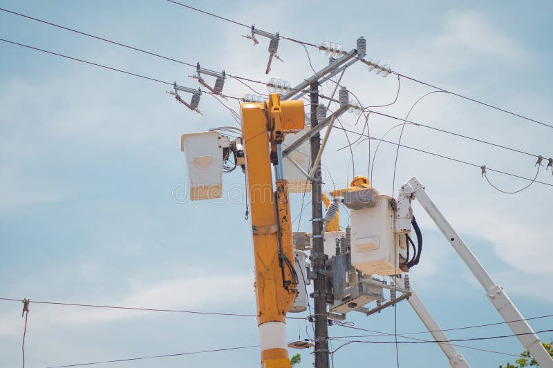 Electricians at Work at a Power Line Pole, Working from High Baskets or ...