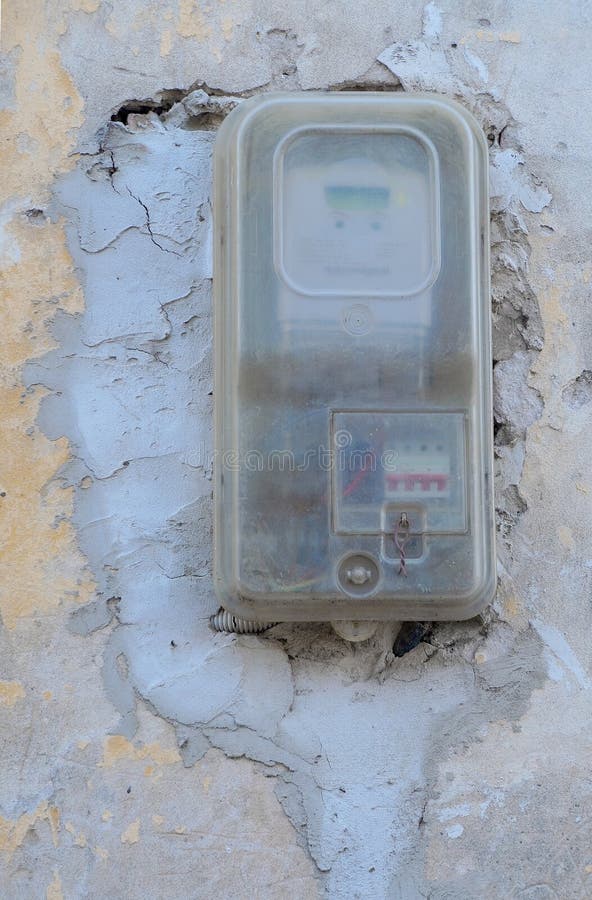 An Electromechanical Electricity Meter on an Old Wall. Meter Measuring ...