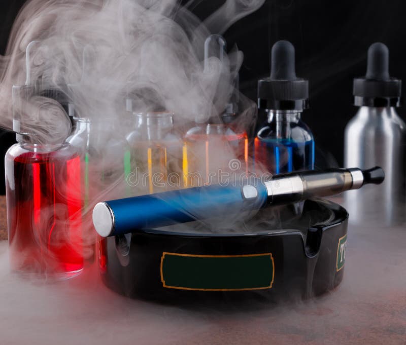 Electronic Cigarette on the Ashtray and Vape Liquids within Vapor on ...