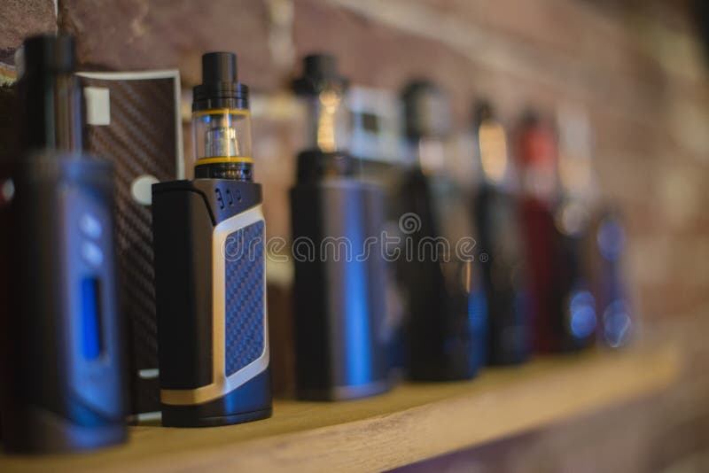 Electronic Cigarette on a Background of Vape Shop. E-cigarette for ...