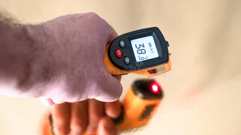 Remote Electronic Thermometer in Hand with High Temperature on the ...