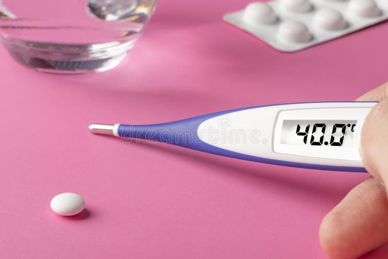 Electronic Thermometer and Pill on a Pink Background. High Temperature ...