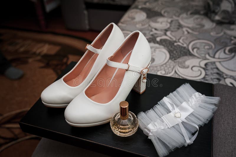 Elegant Bridal Accessories Featuring White Heels, Perfume, and Garter ...