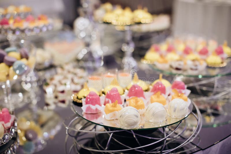 Elegant Candy Bar with Yellow and Pink Cakes on the Mirror Table Stock ...