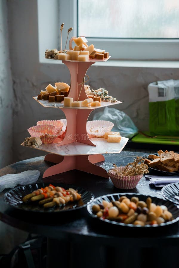 Elegant Cheese Display on Three-Tier Stand with Assorted Accompaniments ...