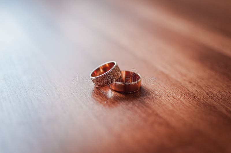Elegant Copper Wedding Rings on a Wooden Surface Stock Image - Image of ...
