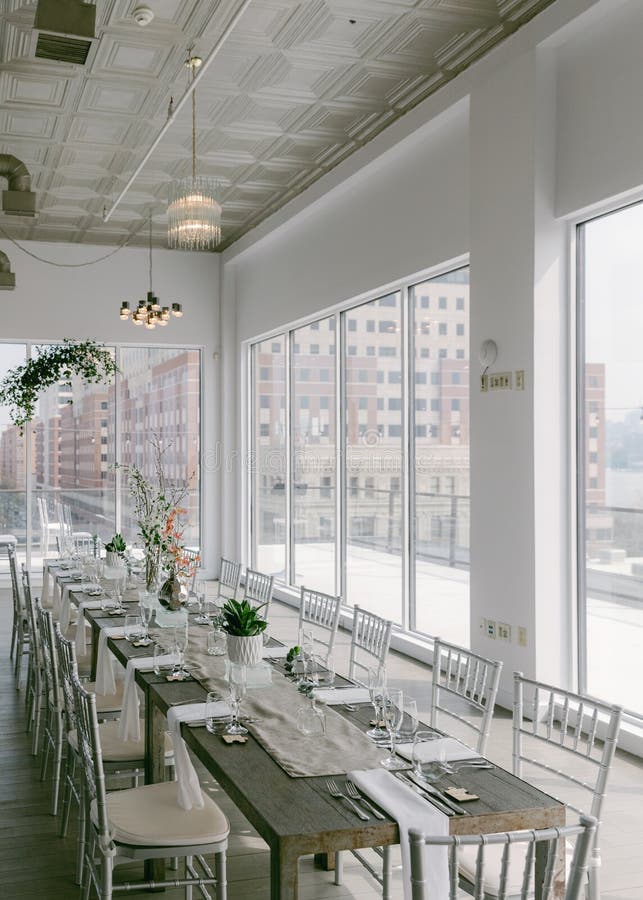 Elegant Dining Setup in a Modern Venue with Large Windows and City ...