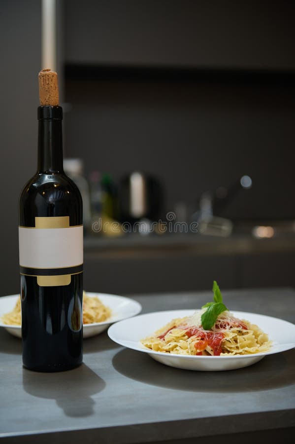 Elegant Dinner Setup with Bottle of Wine and Pasta Plates in a Modern ...