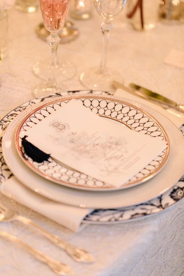 Elegant Dinner Table Setting with Intricate Plate Designs and Menu Card ...