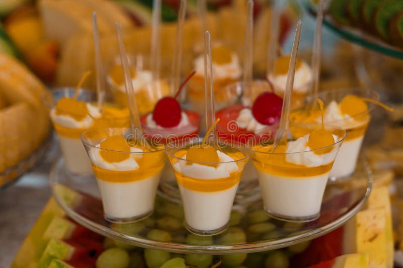 Elegant Display of Gourmet Dessert Cups with Fruit Garnishes on a ...