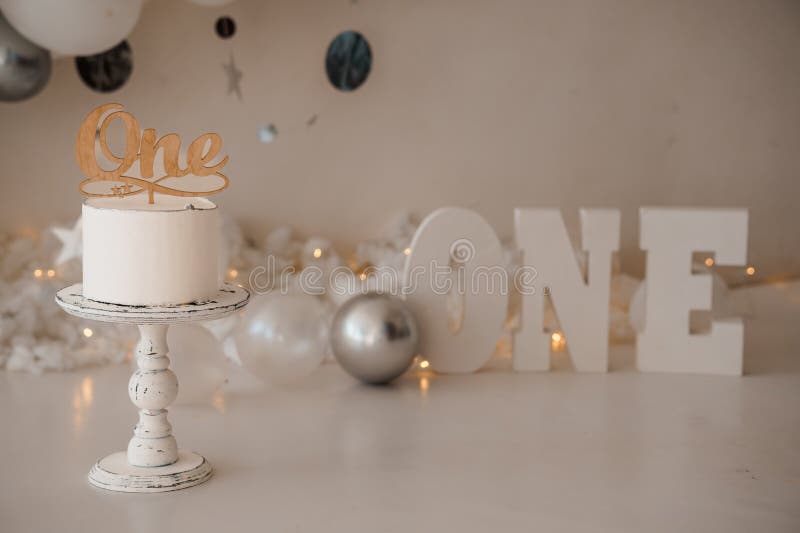Elegant First Birthday Cake Display with Silver and White Decorations ...