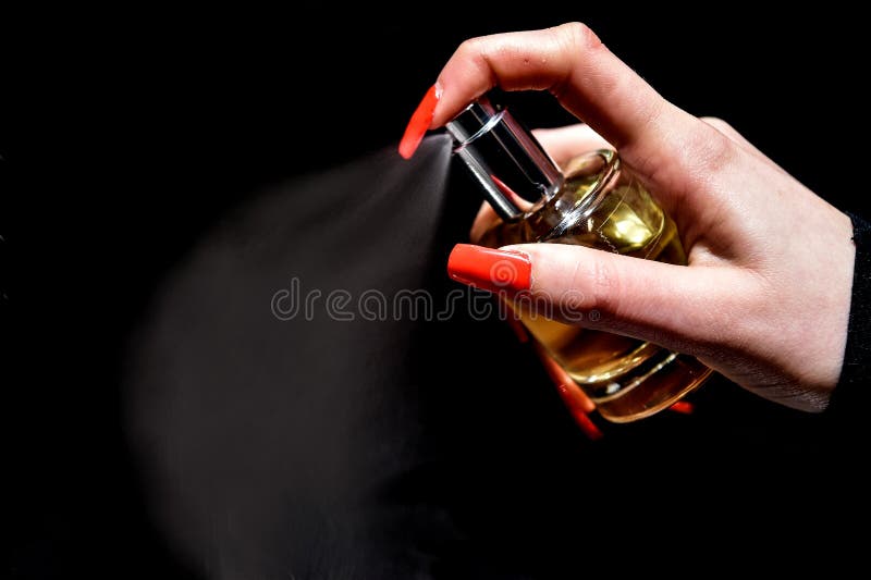 Elegant Hand with Red Nails Sprays a Perfume on a Black Background ...