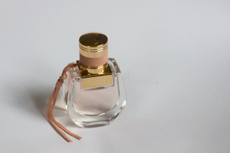 Elegant Perfume Bottle with Gold Cap and Leather Strap on a White ...