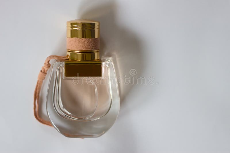 Elegant Perfume Bottle with Gold Cap and Leather Strap on a White ...