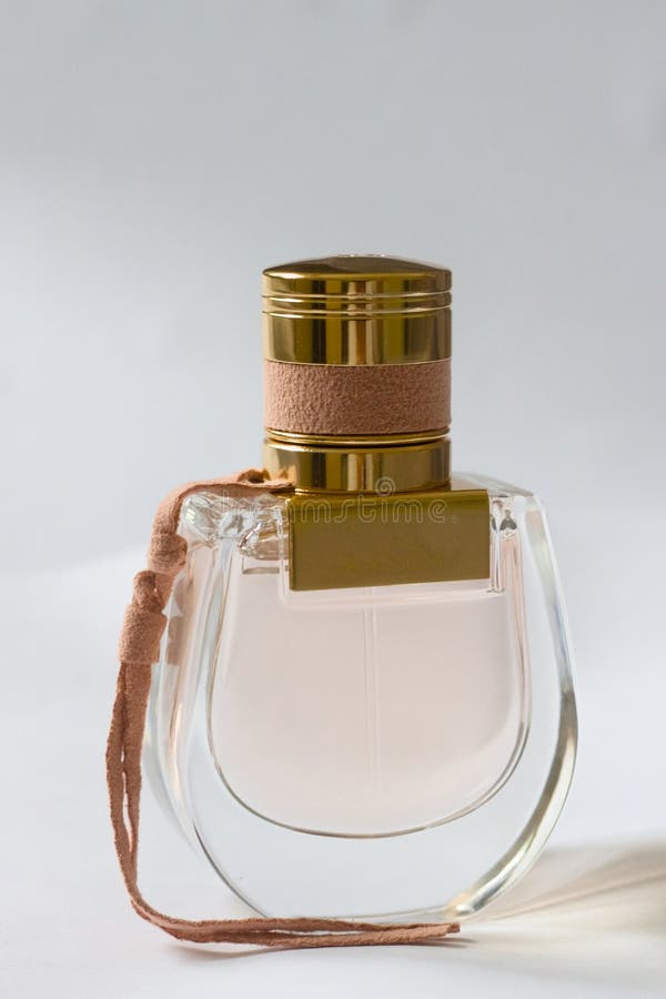 Elegant Perfume Bottle with Gold Cap and Leather Strap on a White ...