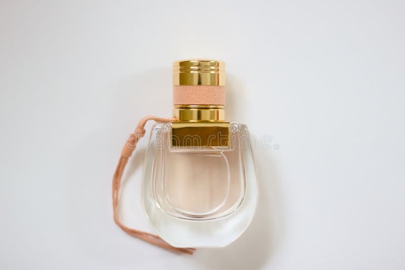 Elegant Perfume Bottle with Gold Cap and Leather Strap on a White ...