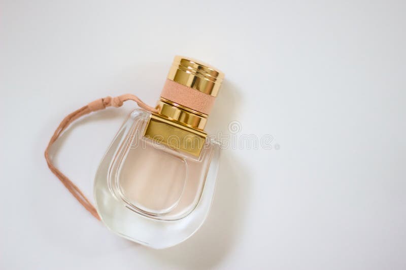 Elegant Perfume Bottle with Gold Cap and Leather Strap on a White ...