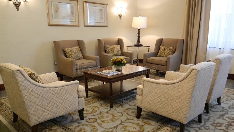 Elegant Seating Area with Armchairs, Coffee Table, and Soft Lighting in ...