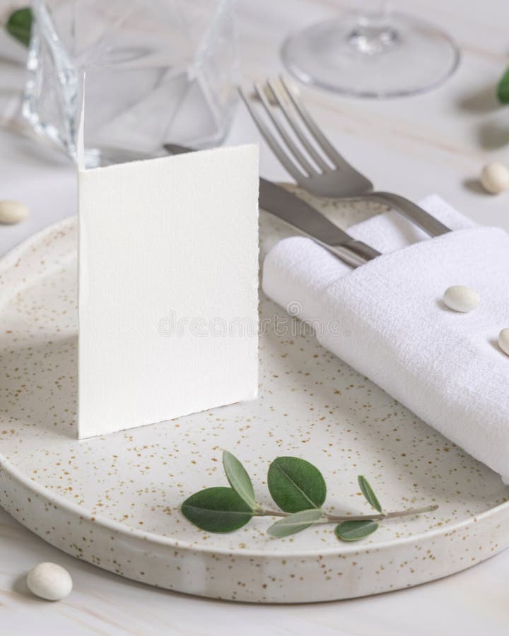 Table Setting with Folded Card Decorated with Eucalyptus Branches Close ...