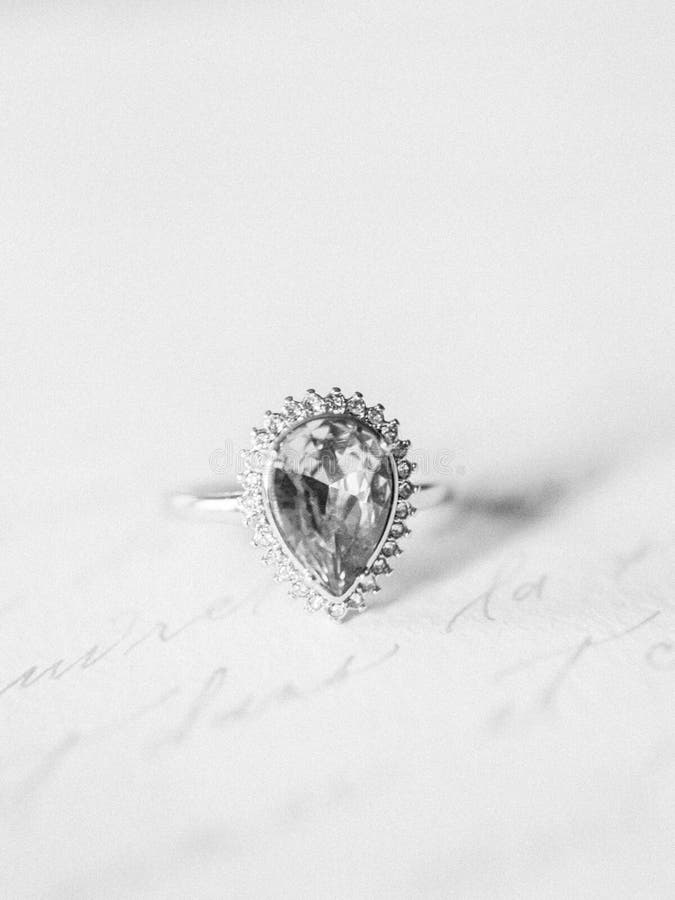 Elegant Teardrop Engagement Ring Resting on Delicate Handwritten Note in Soft Lighting Stock ...