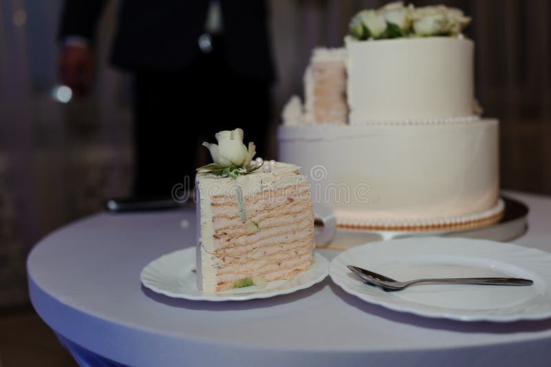 Elegant Wedding Cake with White Rose Decoration and Slice on Plate ...
