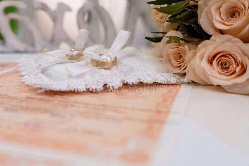 Elegant Wedding Rings and Floral Arrangement on Lace Table Setting ...