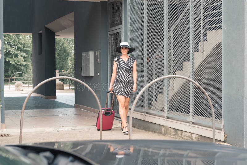 Elegant Woman in Mini Dress Walking Towards the Car with Suitcase Stock ... Elegant Woman in Mini Dress Walking Towards the Car with Suitcase Stock ...
