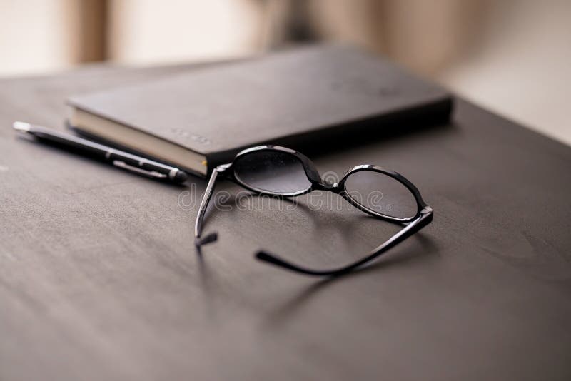 Elegant Writing Setup with a Notebook, Pen, and Glasses on a Wooden ...