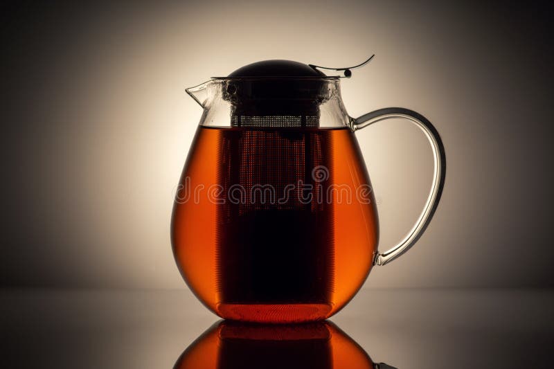 Elegantly Designed Glass Teapot with Amber-colored Tea, Glowing Against ...