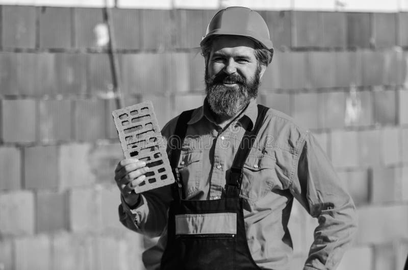 Element in Masonry Construction. Builder Hold Brick. Bearded Man Wear ...