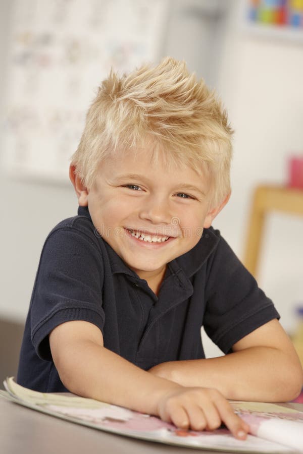 Elementary Age Schoolboy Reading Book in Class Stock Photo - Image of ...