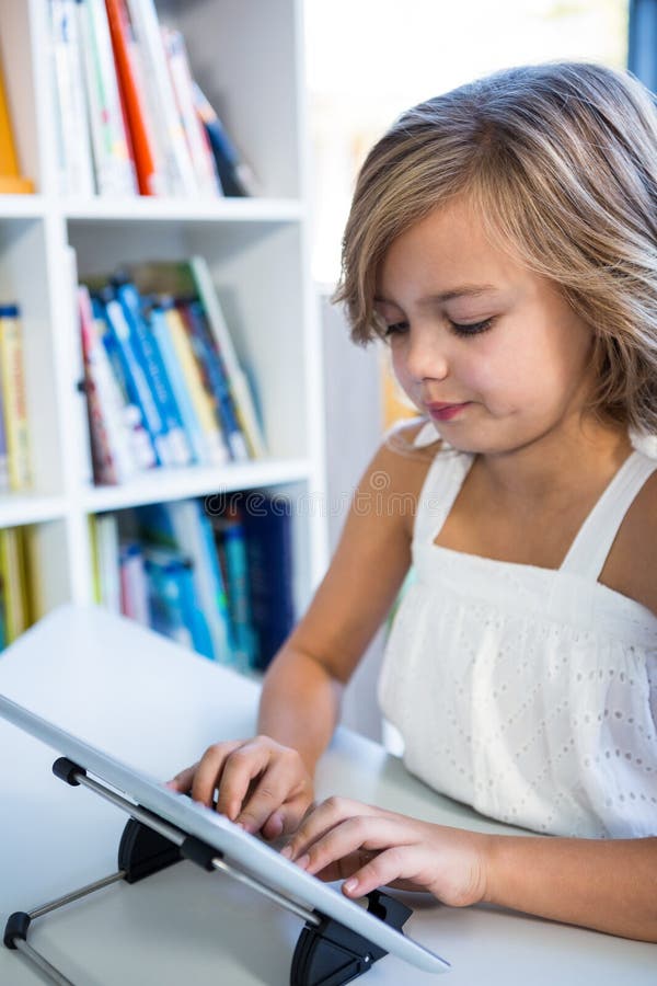 Elementary Girl Using Digital Tablet in Library Stock Image - Image of ...