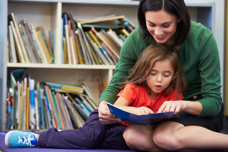 Elementary Pupil Reading with Teacher in Classroom Stock Image - Image ...