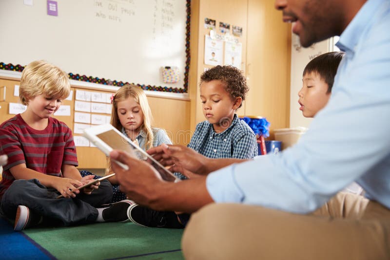 Elementary School Class Sitting Cross Legged Using Tablets Stock Photo ...