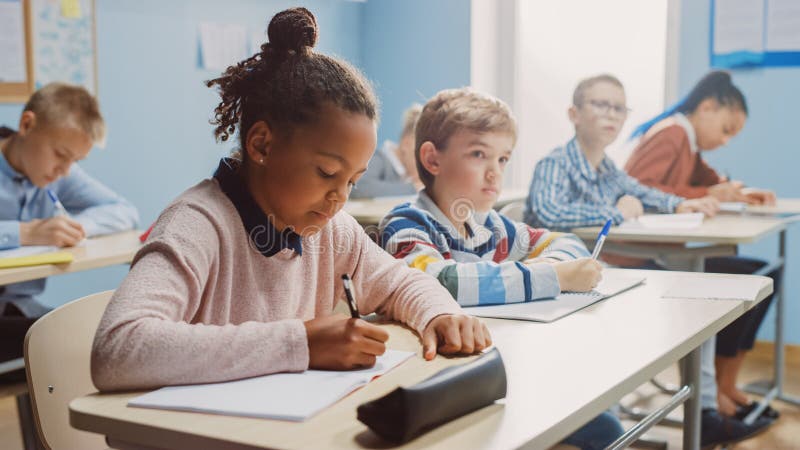 In Elementary School Classroom Brilliant Black Girl Writes in Exercise ...