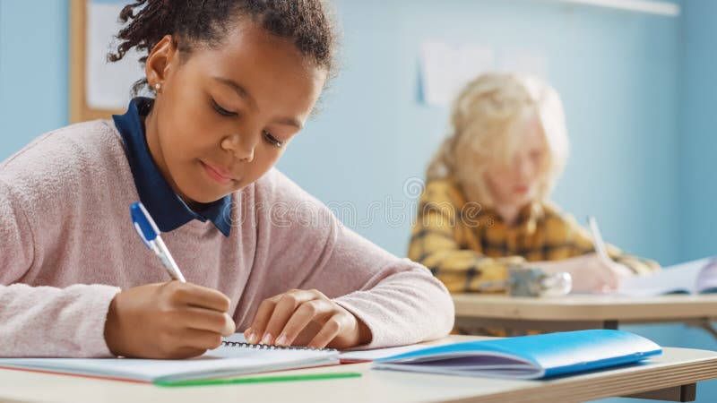 In Elementary School Classroom Brilliant Black Girl Writes in Exercise ...