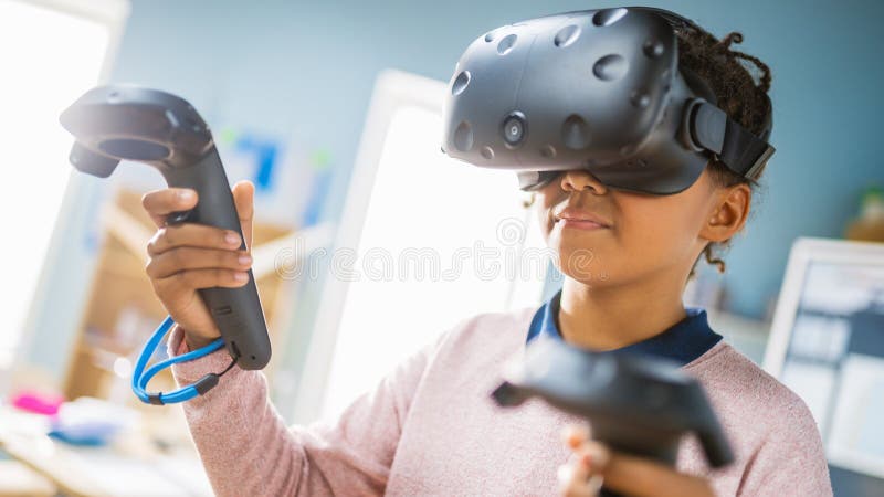 Elementary School Computer Science Class: Cute Girl Wearing Augmented Reality Headset and Using ...