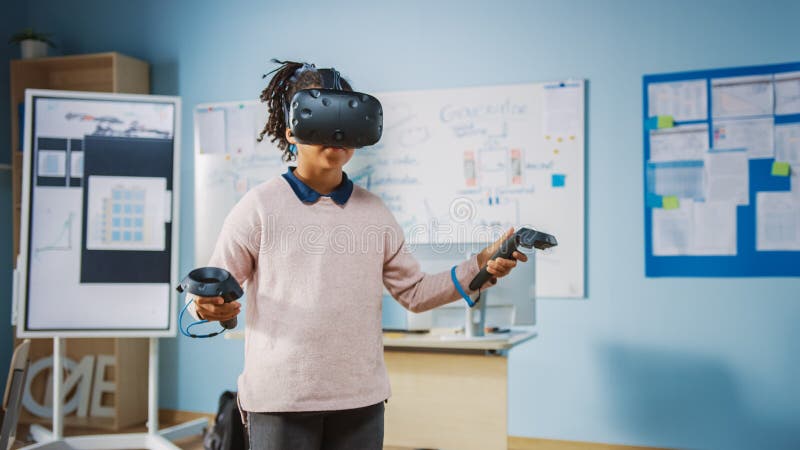Elementary School Computer Science Class: Cute Girl Wearing Augmented Reality Headset and Using ...