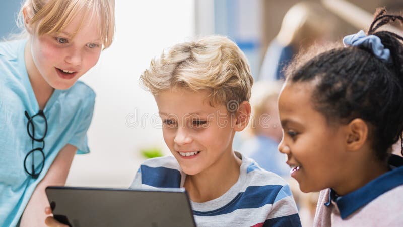 Elementary School Computer Science Class: Two Girls and Boy Use Digital ...