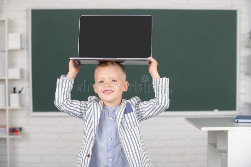 Elementary School Kid Holding Laptop on Head in Computer Class. Stock ...
