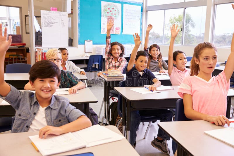 Elementary School Kids in a Classroom Raising Their Hands Stock Photo ...