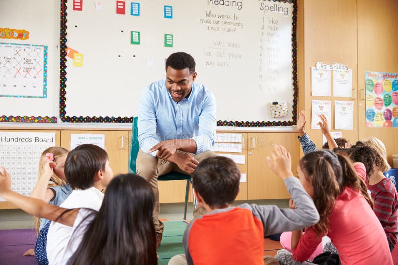 Elementary School Kids Sitting Around Teacher in a Classroom Stock ...