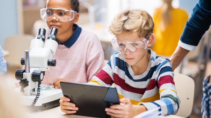Elementary School Science Classroom: Boy Uses Digital Tablet Computer ...