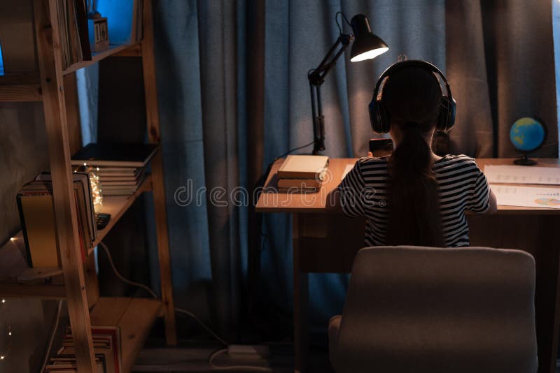 Elementary School Student Studying at Home at Night, Doing Homework in ...
