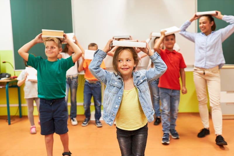 Elementary School Students Balancing Books Stock Photo - Image of ...