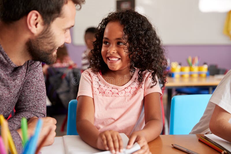Elementary School Teacher Giving Female Pupil One To One Support in ...